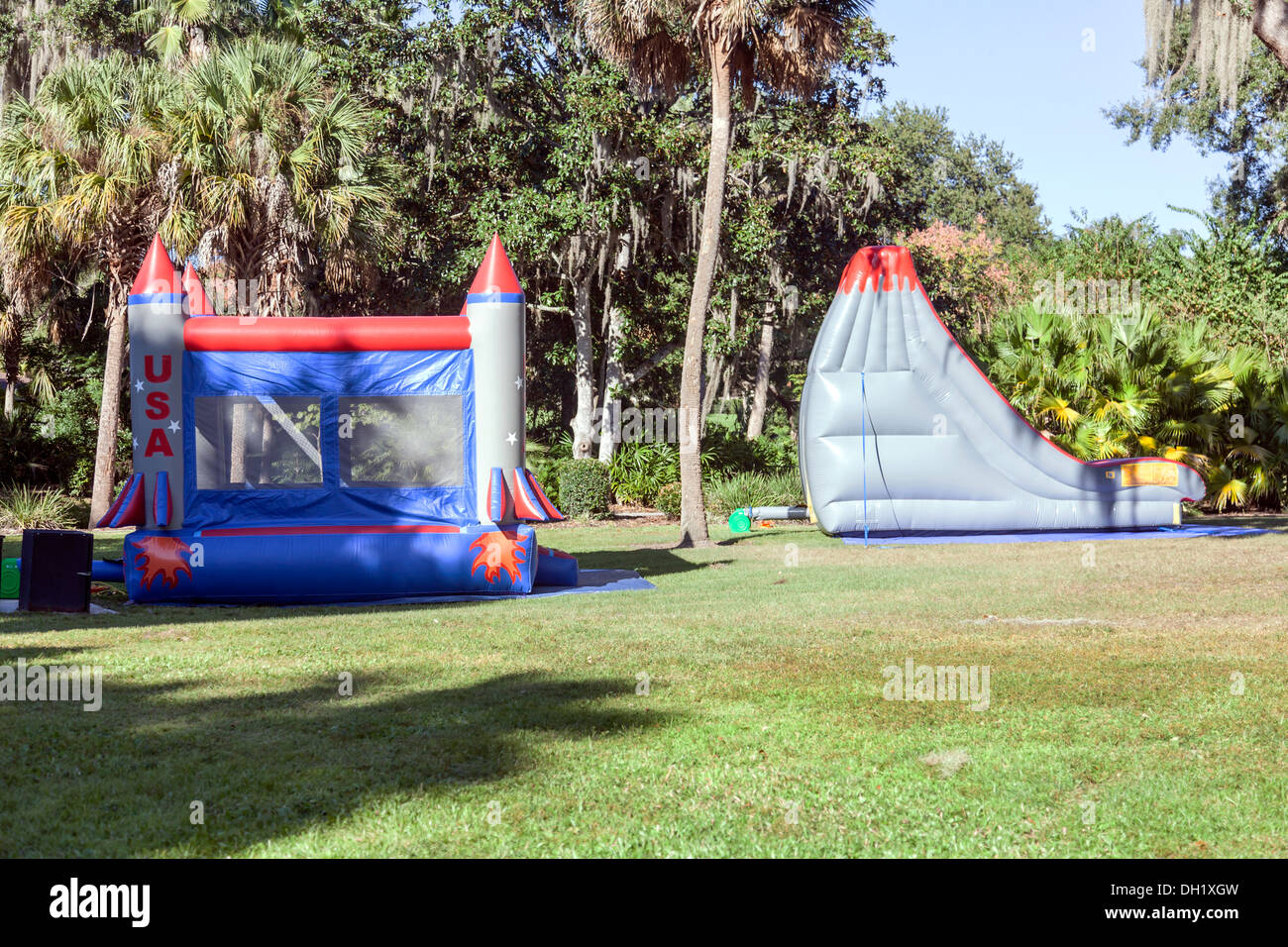 Inflatable USA rockets bounce house and slide set up in a public park ...