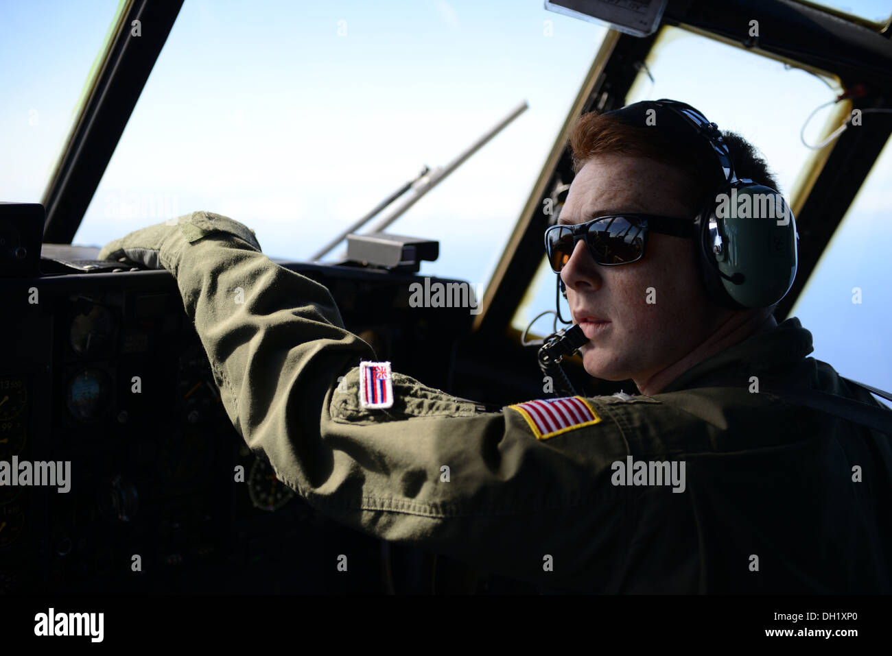 Lt. j.g. Matthew Chase scans the sky in a Coast Guard HC-130 Hercules ...