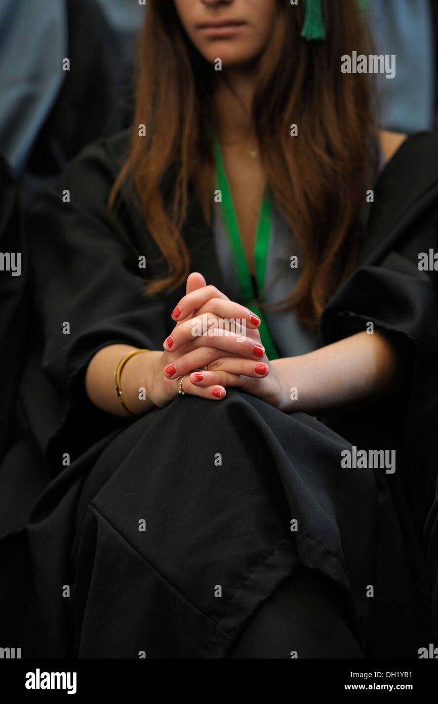 A female student clasps her hands at a graduation ceremony Stock Photo ...