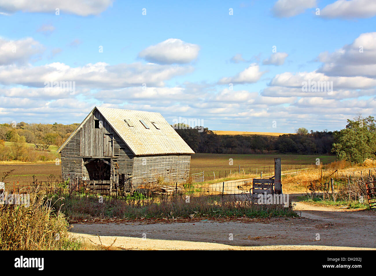 an empty old abandoned farm building, has weathered wood beams that are ...