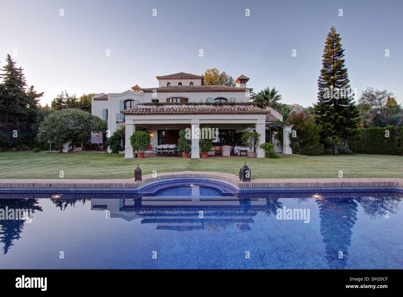 Blue swimming pool in well maintained garden of large Spanish villa ...