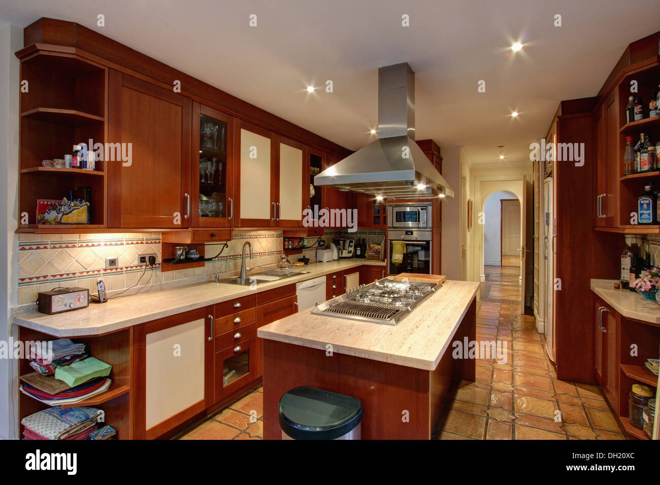 Large extractor above hob in island unit in modern kitchen with cherry ...