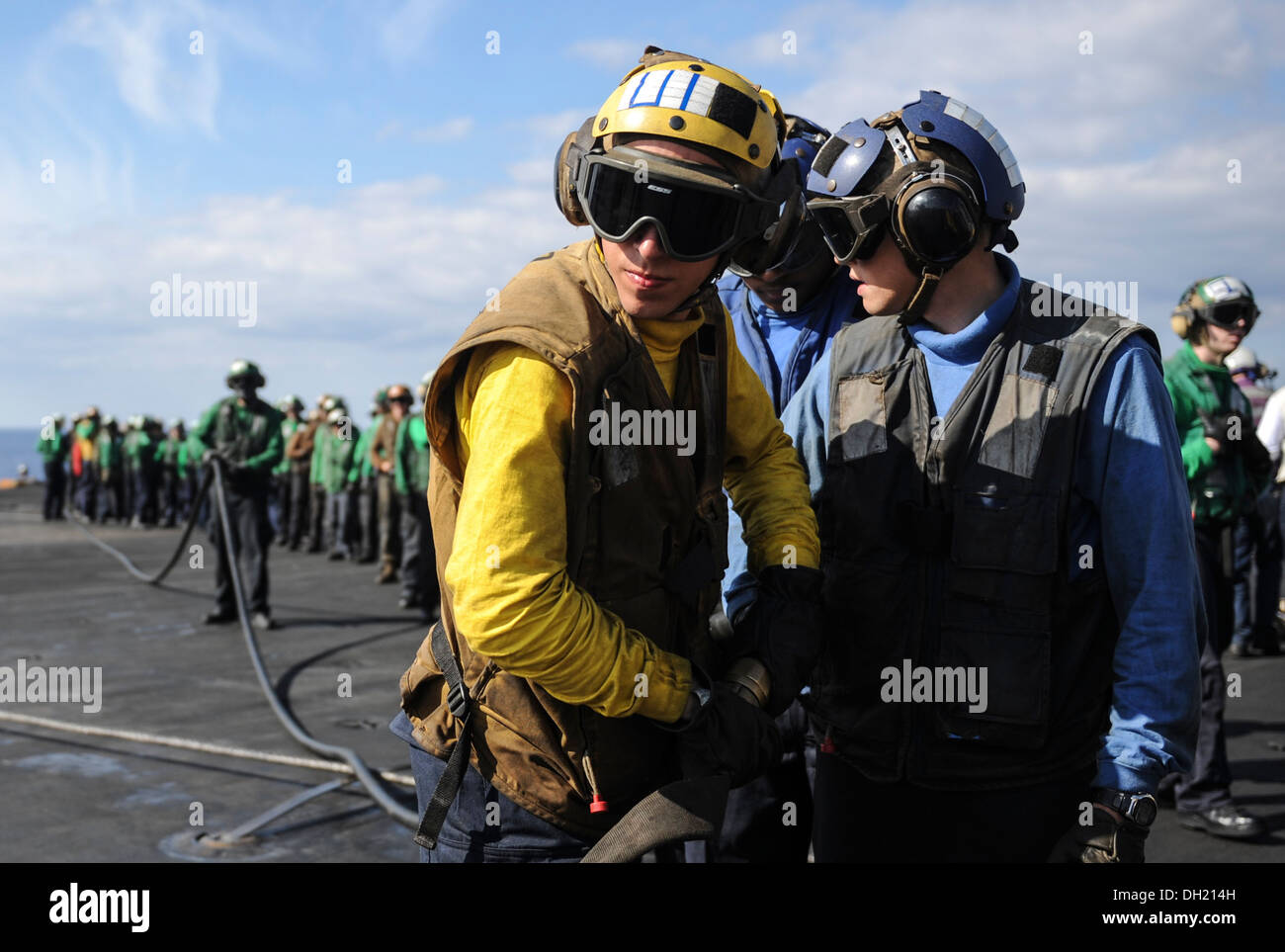Sailors and Marines fight a simulated fire on the flight deck of the ...