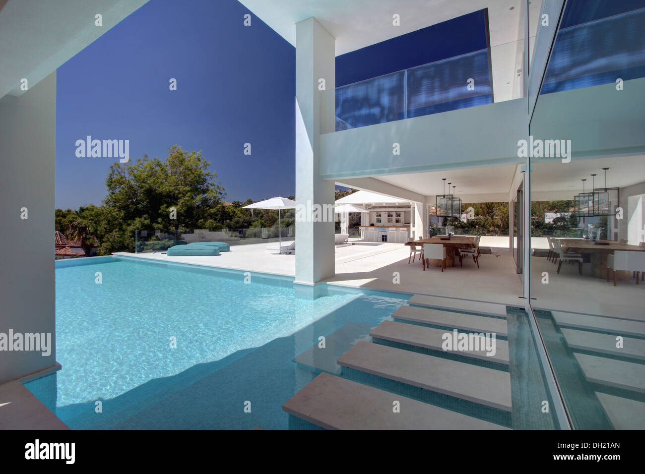 Paving across swimming pool of large modern Spanish villa with spacious ...