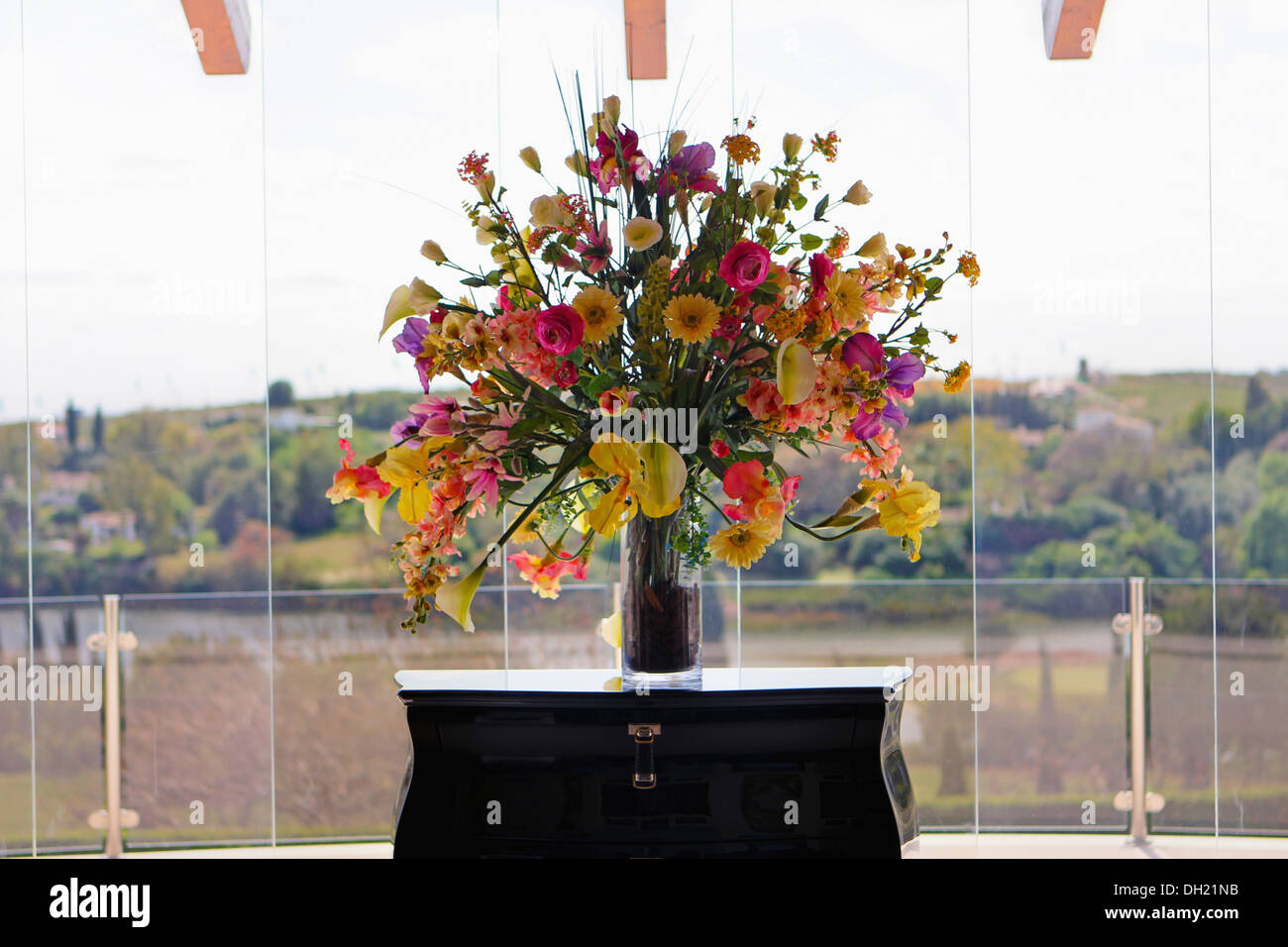 Formal floral arrangement of pink and yellow summer flowers in vase on ...