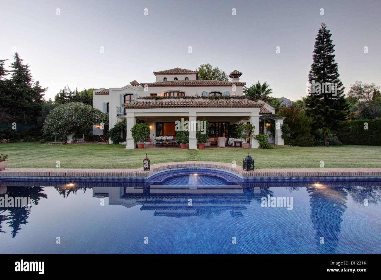 Blue swimming pool in front of large villa with spacious veranda in ...