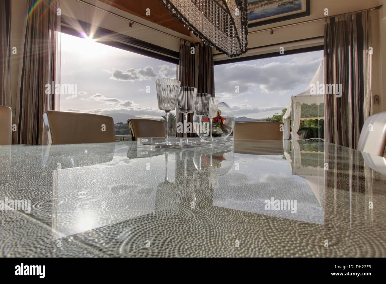 Wineglasses on glass topped textured metal table in modern Spanish ...