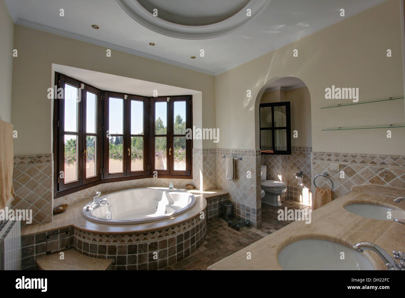 Bay window above circular bath in tiled bathroom in newly built villa ...