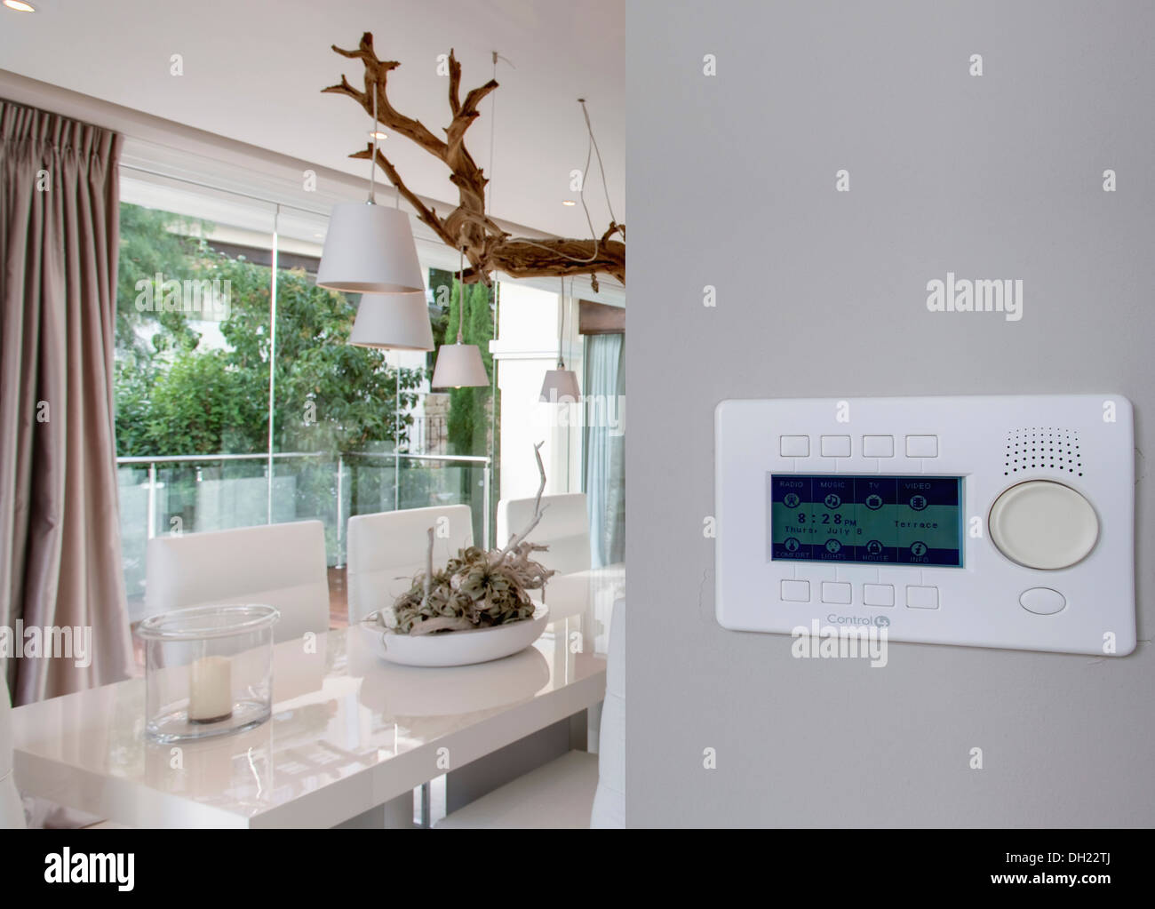 Electronic controls on wall of modern dining room with lighting fixed ...