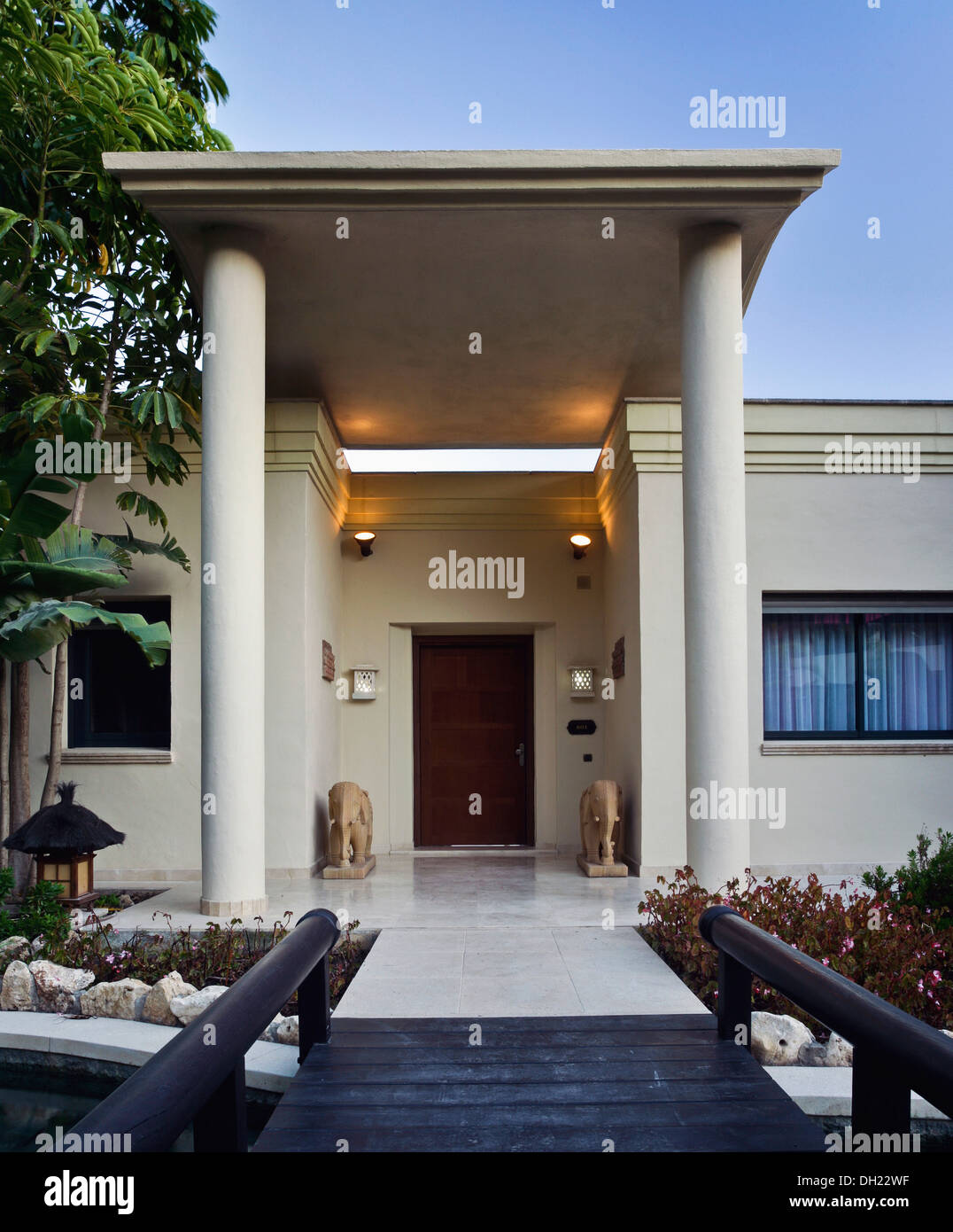 Wooden bridge to modern Spanish villa with large, pillared porch with ...