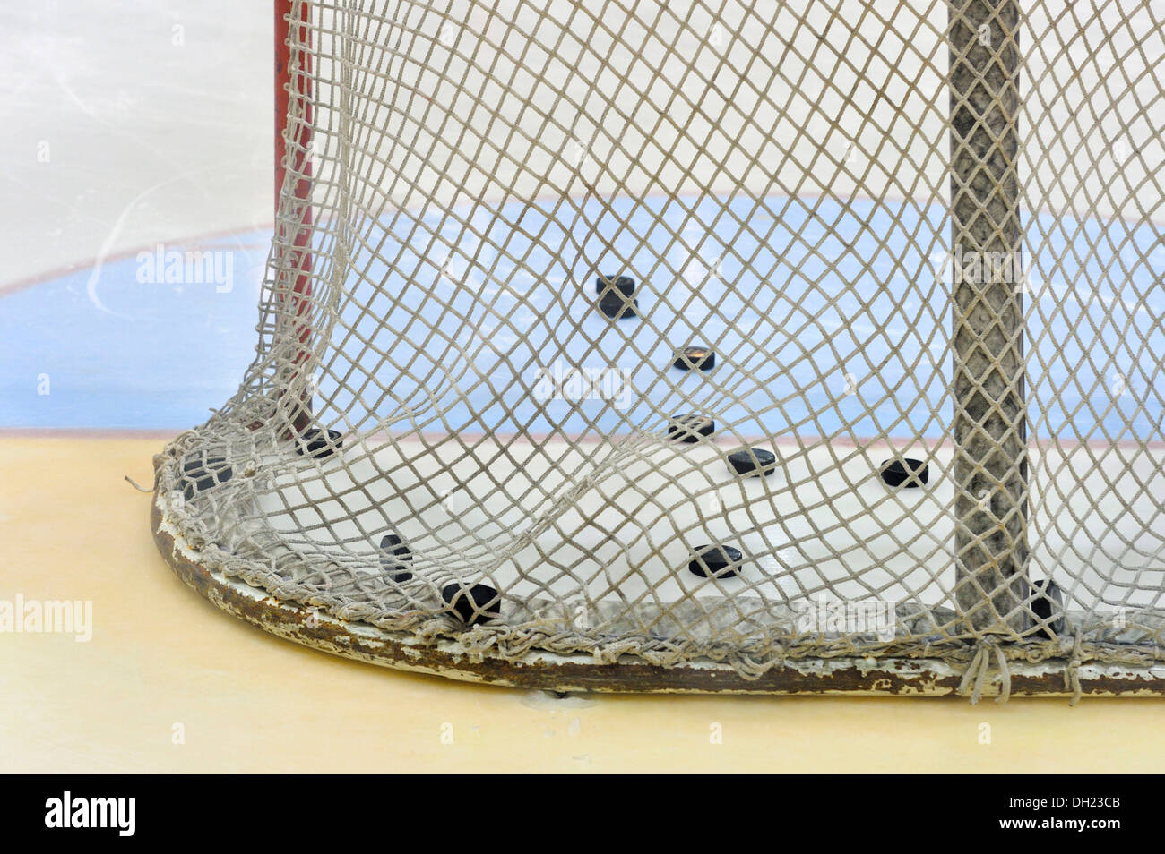 Several pucks in an ice hockey goal Stock Photo - Alamy