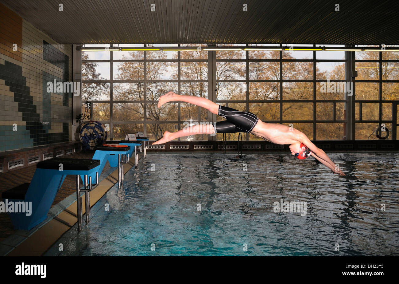 Boy, swimmer, 12 or 13 years, jumping from the starting block into the ...