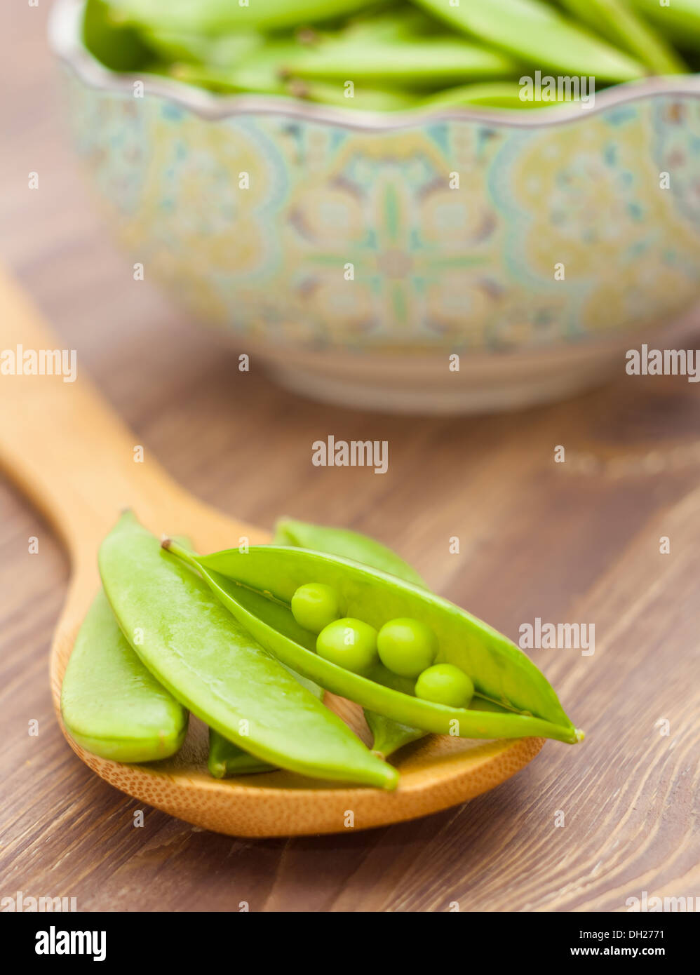 Pea pods on spoon, wooden background Stock Photo - Alamy