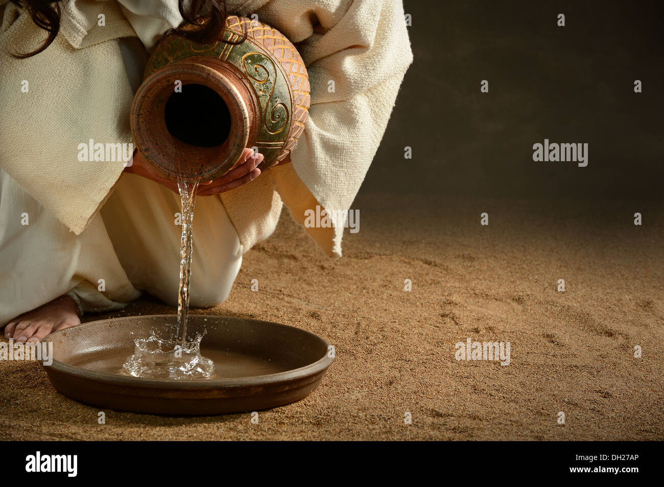 Jesus pouring water from jug over dark background Stock Photo - Alamy