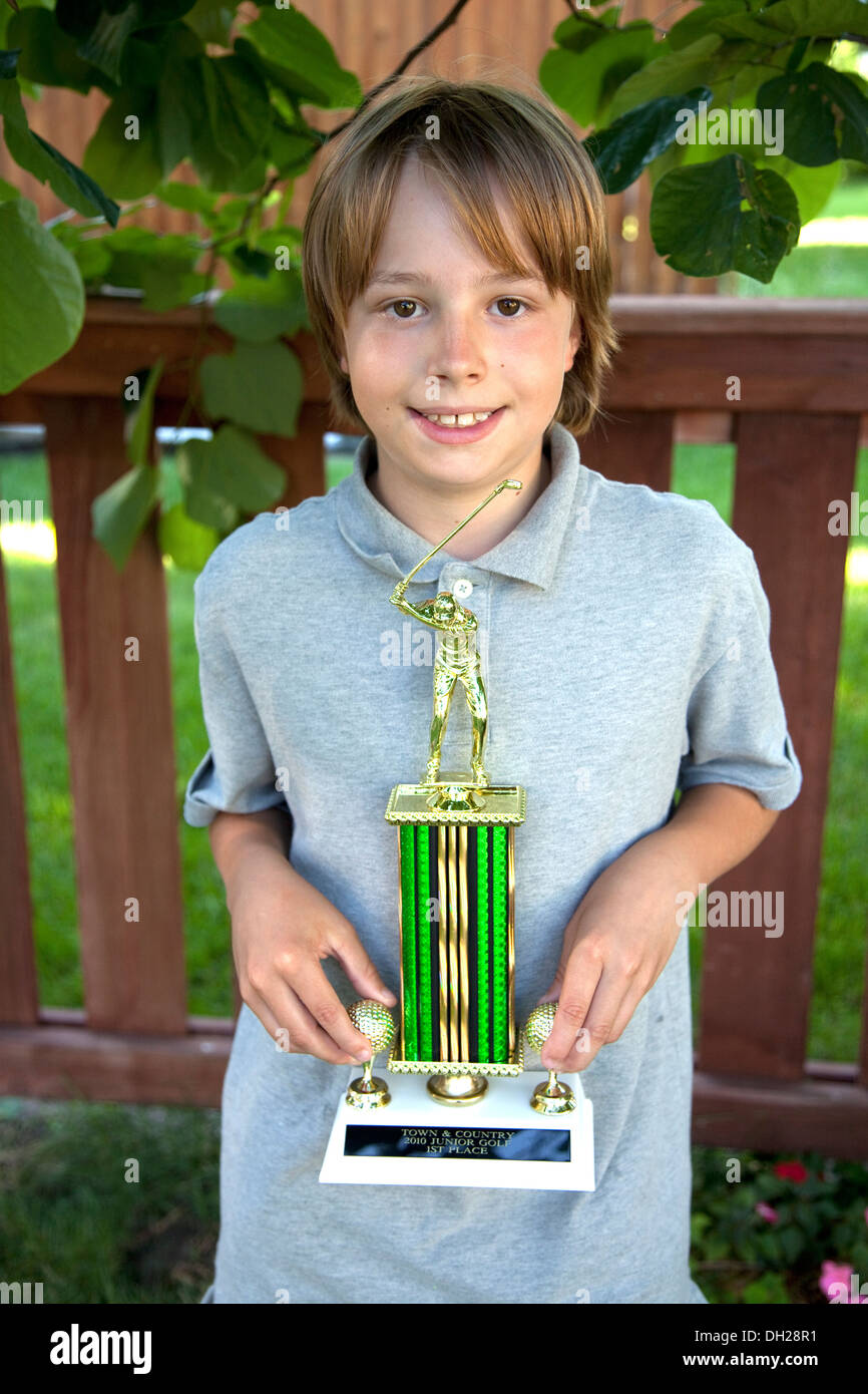 Boy age 11 proudly holds his first place golf trophy. St Paul Minnesota ...