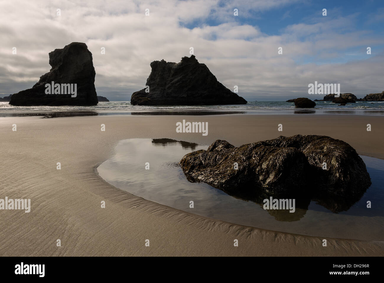 A calm beach scene with rocks and clouds Stock Photo - Alamy
