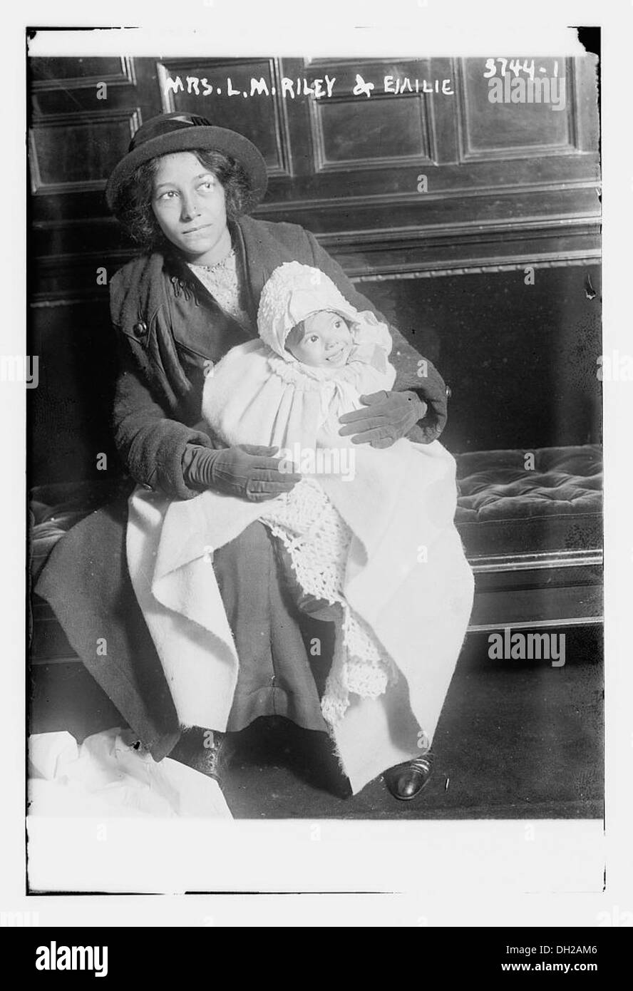This historical photograph shows Mrs. L.M. Riley and Emilie, offering a ...