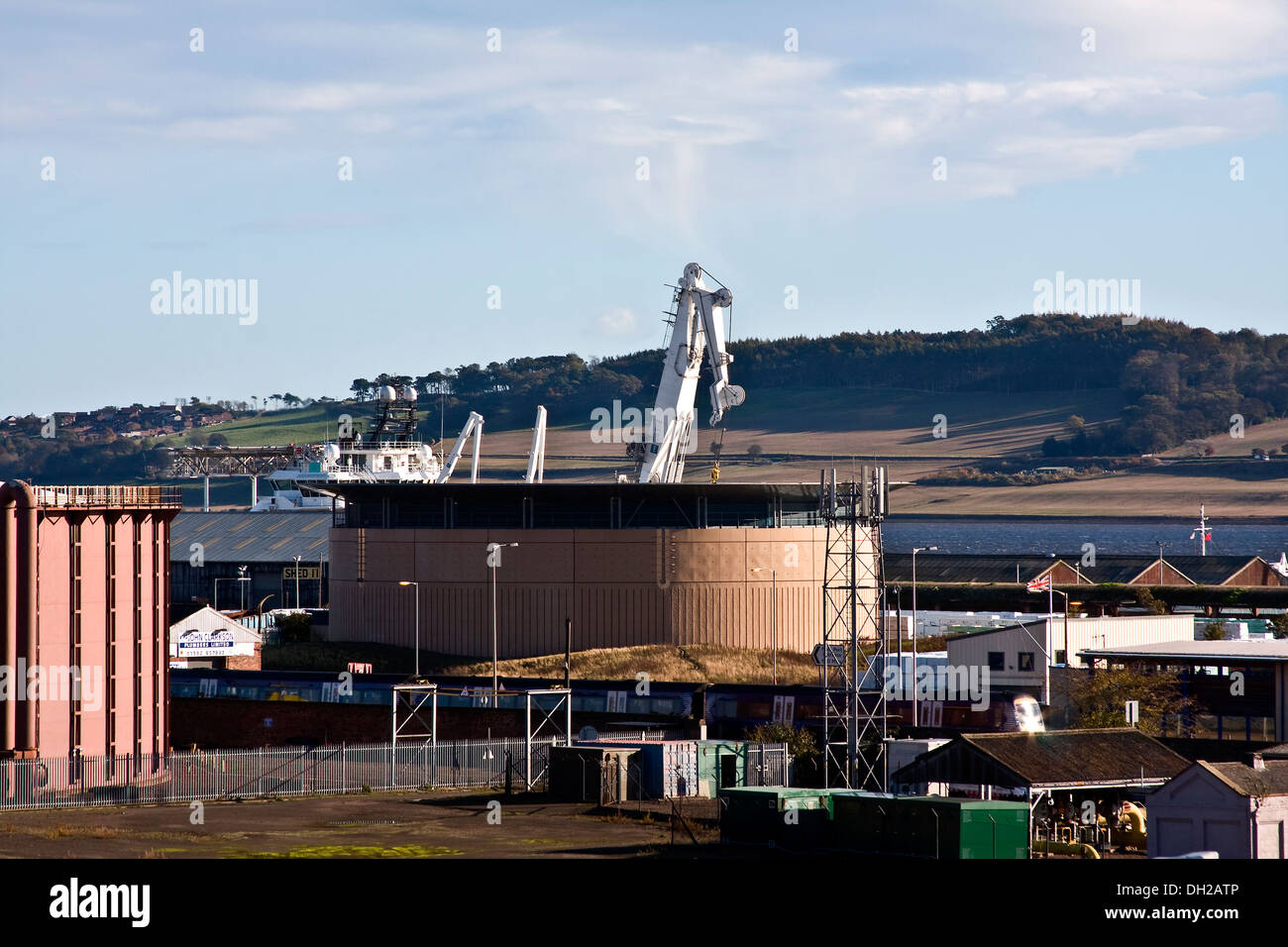 Scotrail train passing between two Oil and Gas refinery tanks inside ...