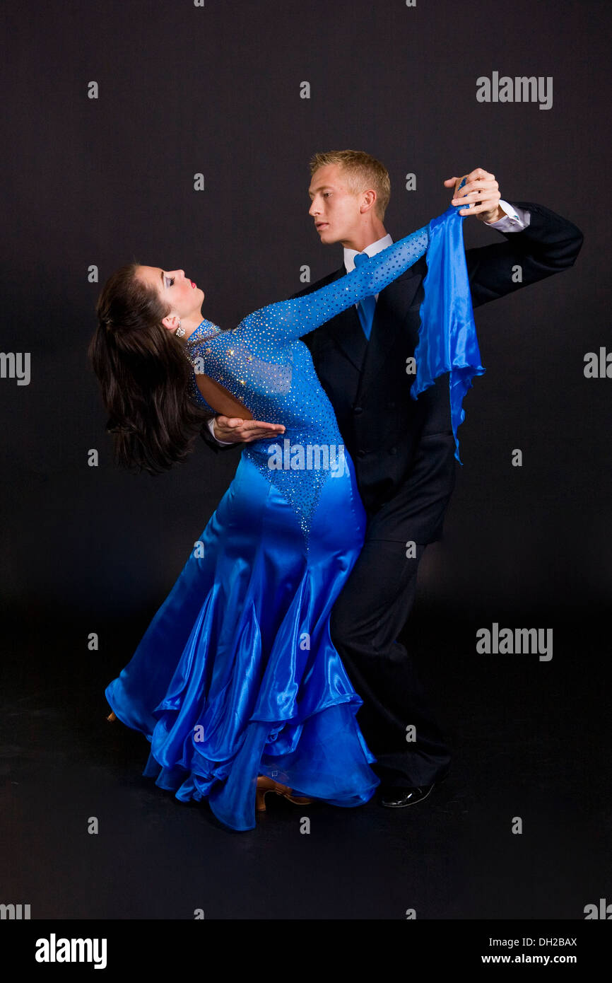 Young ballroom dancers in formal costumes posing against a solid ...