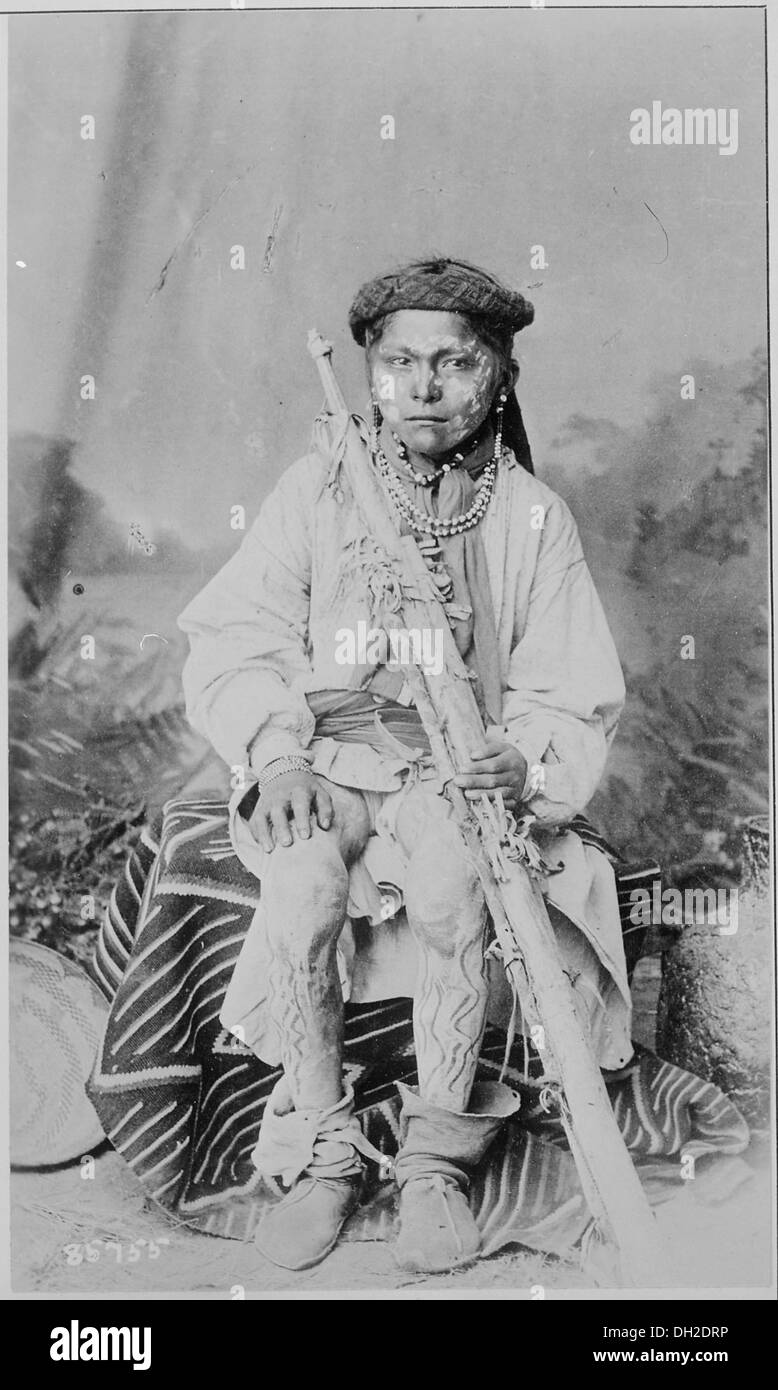 An Apache boy is pictured with traditional face and leg paint, a part ...