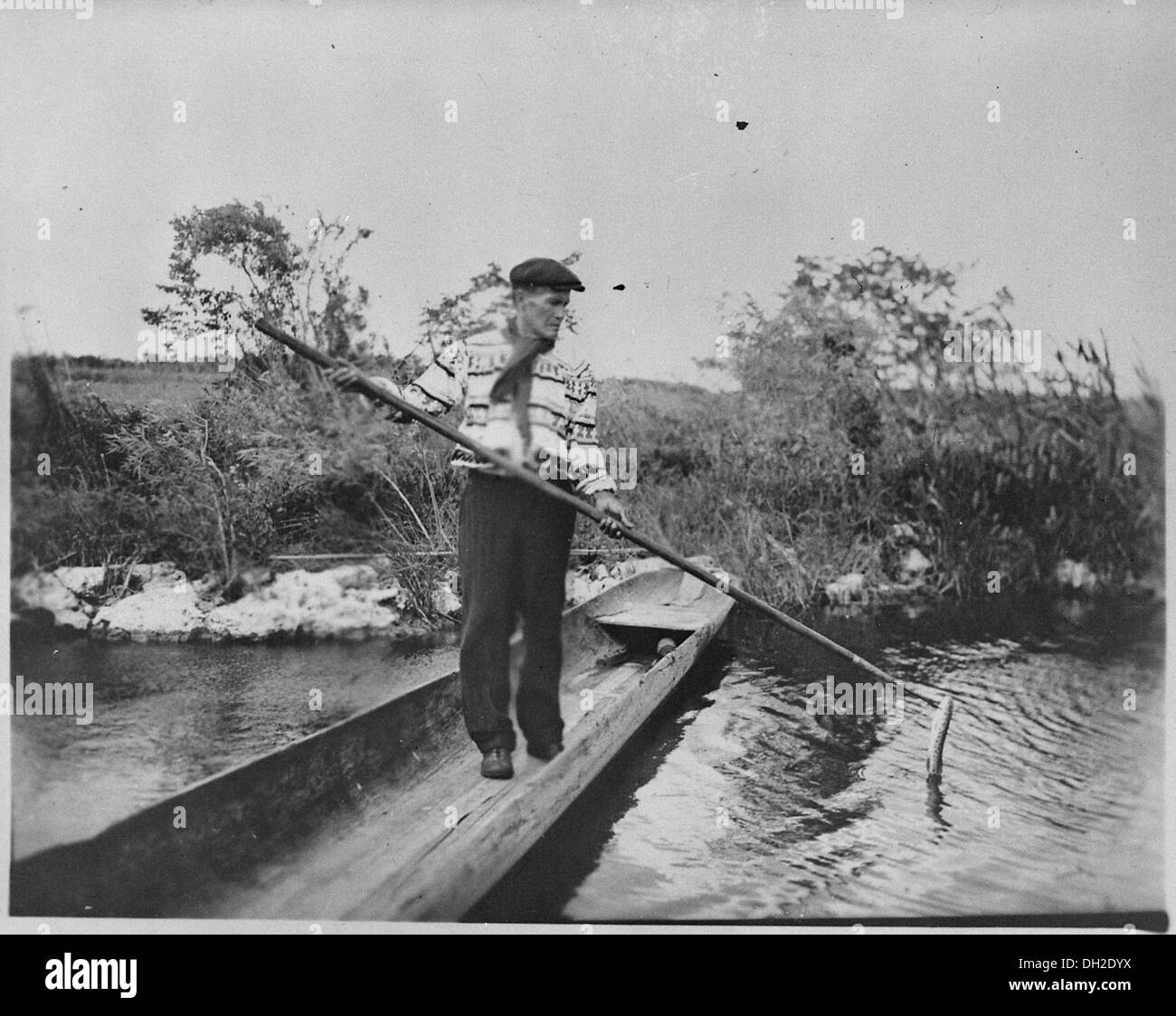 A Seminole fisherman uses a spear to catch a garfish from a traditional ...