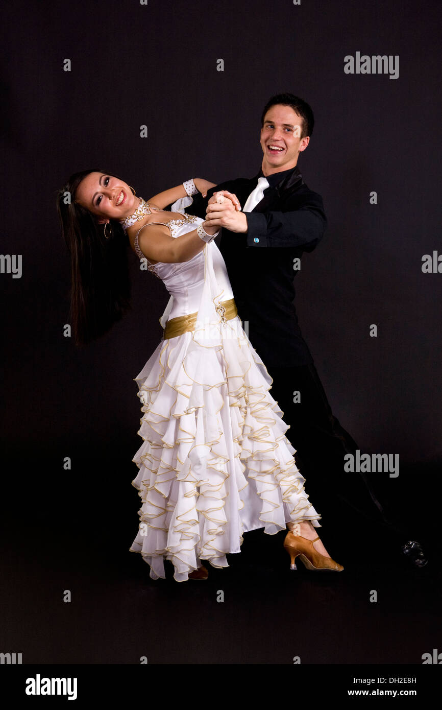 Young ballroom dancers in formal costumes posing against a solid ...