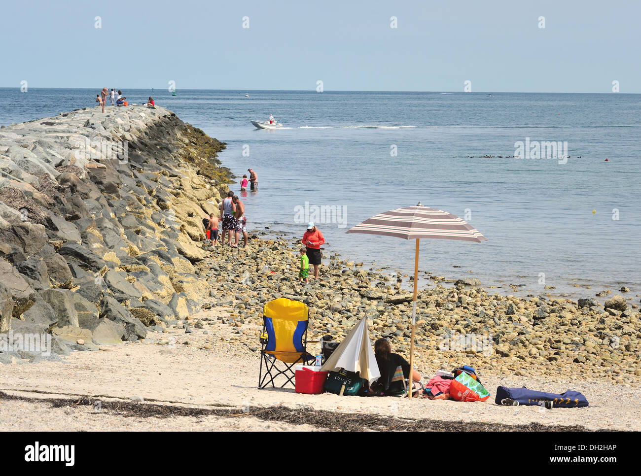 Families relaxing on beach and gathering mussels and shells at the east ...