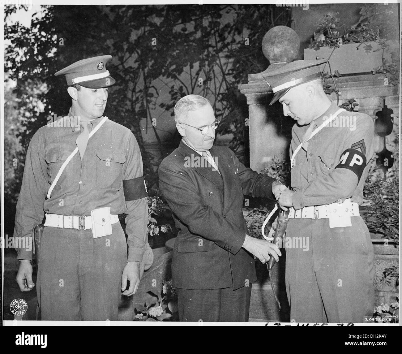 President Harry S. Truman is seen inspecting the pistol of Cpl. John ...