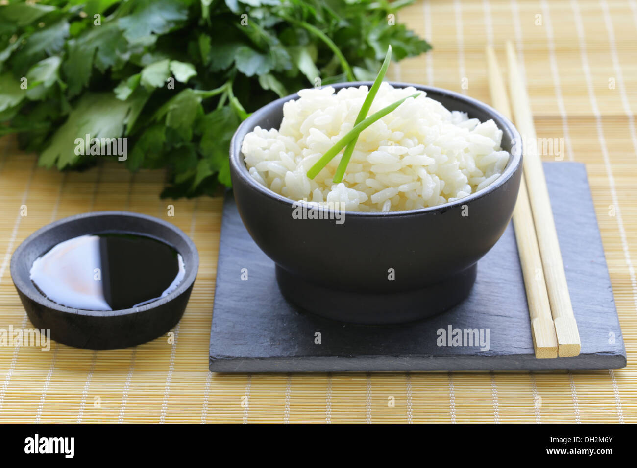 boiled white rice in a black bowl, Asian style Stock Photo - Alamy