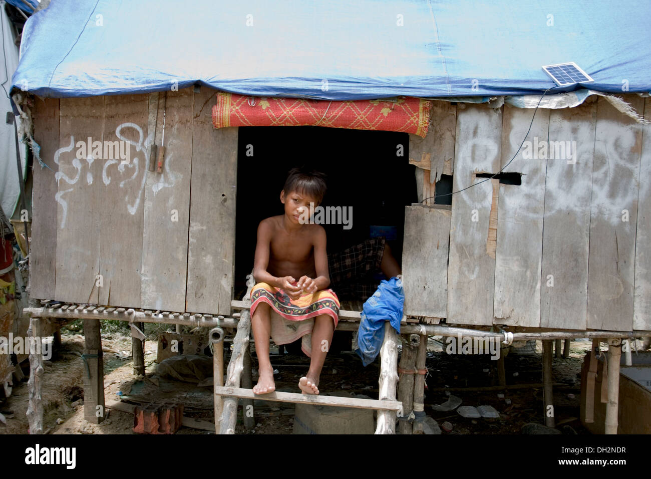 A child laborer boy who works in the recycling industry is sitting in ...