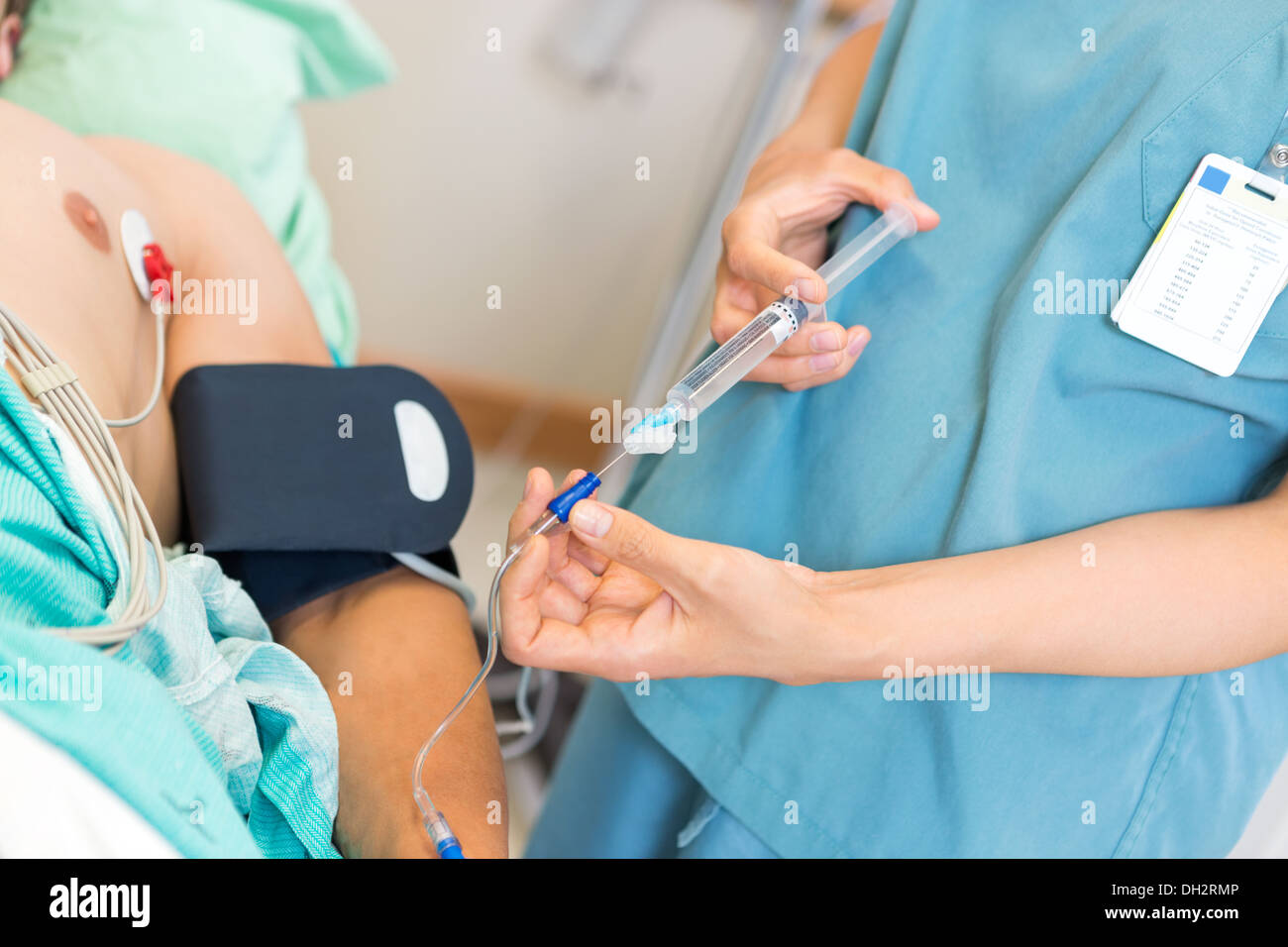 Nurse Injecting Dosage In IV Tube Attached To Patient Stock Photo - Alamy