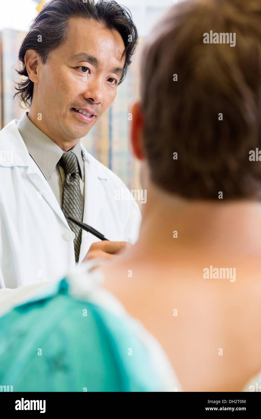 Doctor Looking At Patient While Discussing Report Stock Photo - Alamy