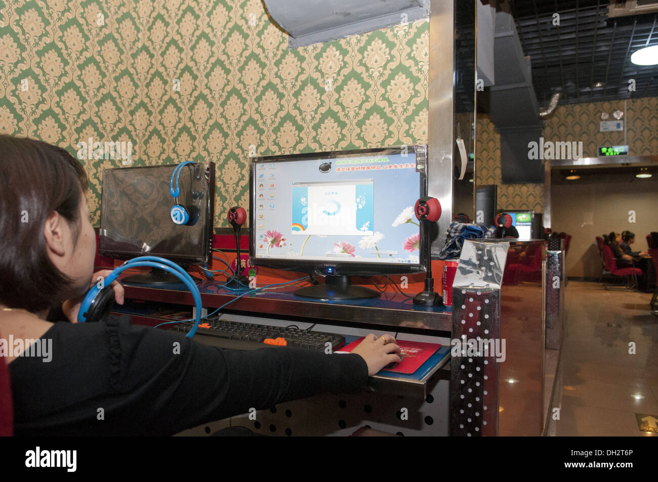 A young Chinese woman an internet cafe, or cyberbar uses Skype on a ...