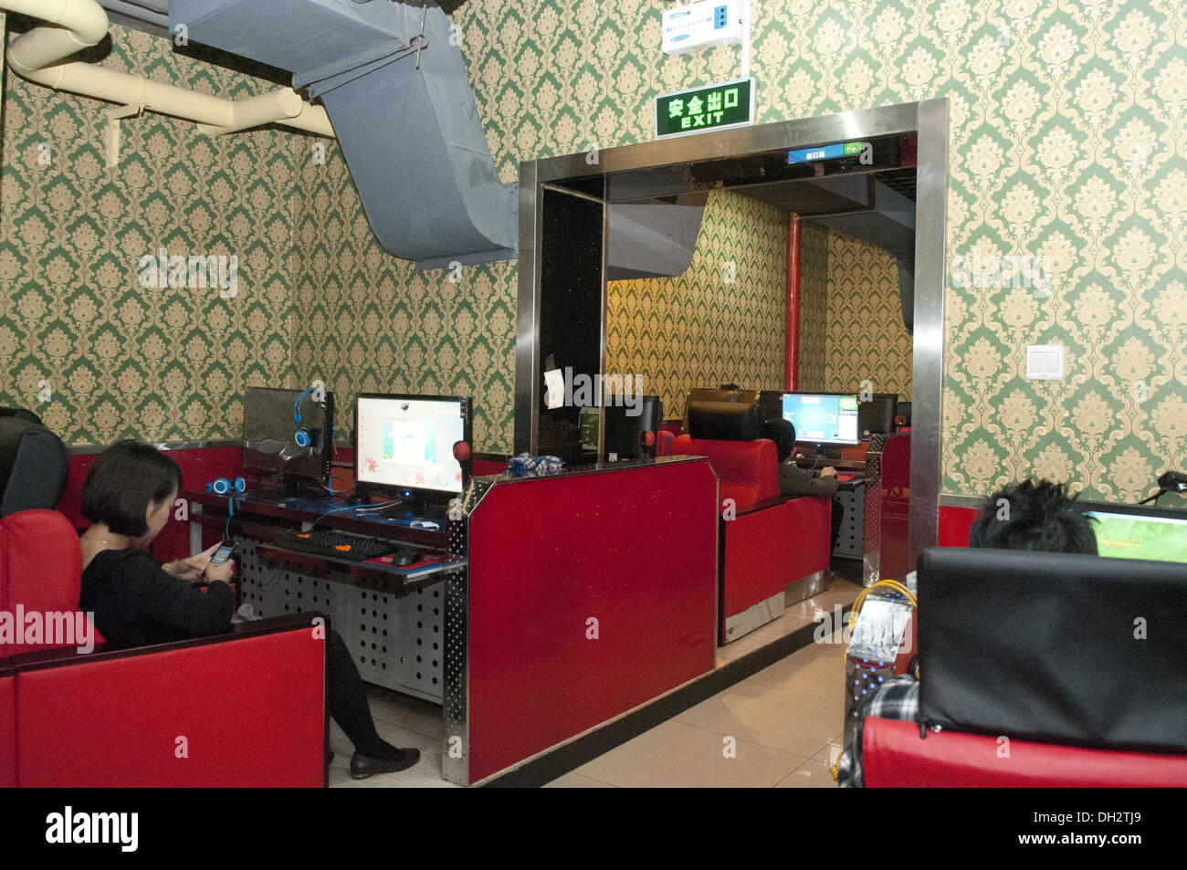 A young Chinese woman an internet cafe, or cyberbar uses Skype on a ...
