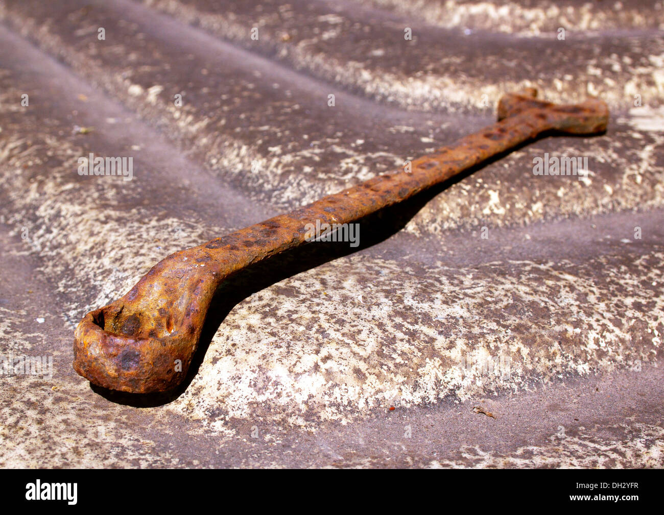 Isolated old rusted spanner on sloping textured fiberglass surface ...