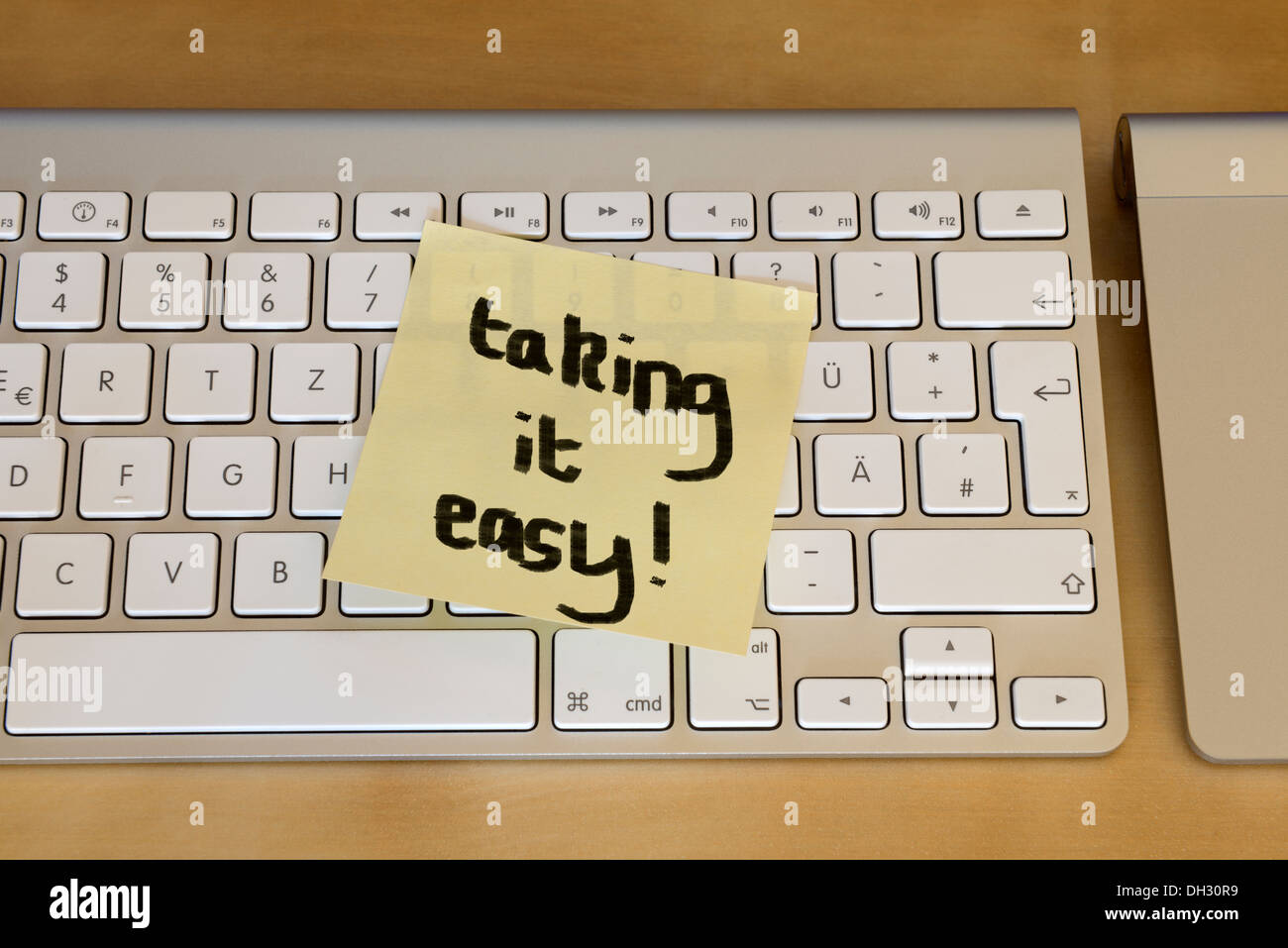 'taking it easy' post-it note on computer keyboard Stock Photo - Alamy