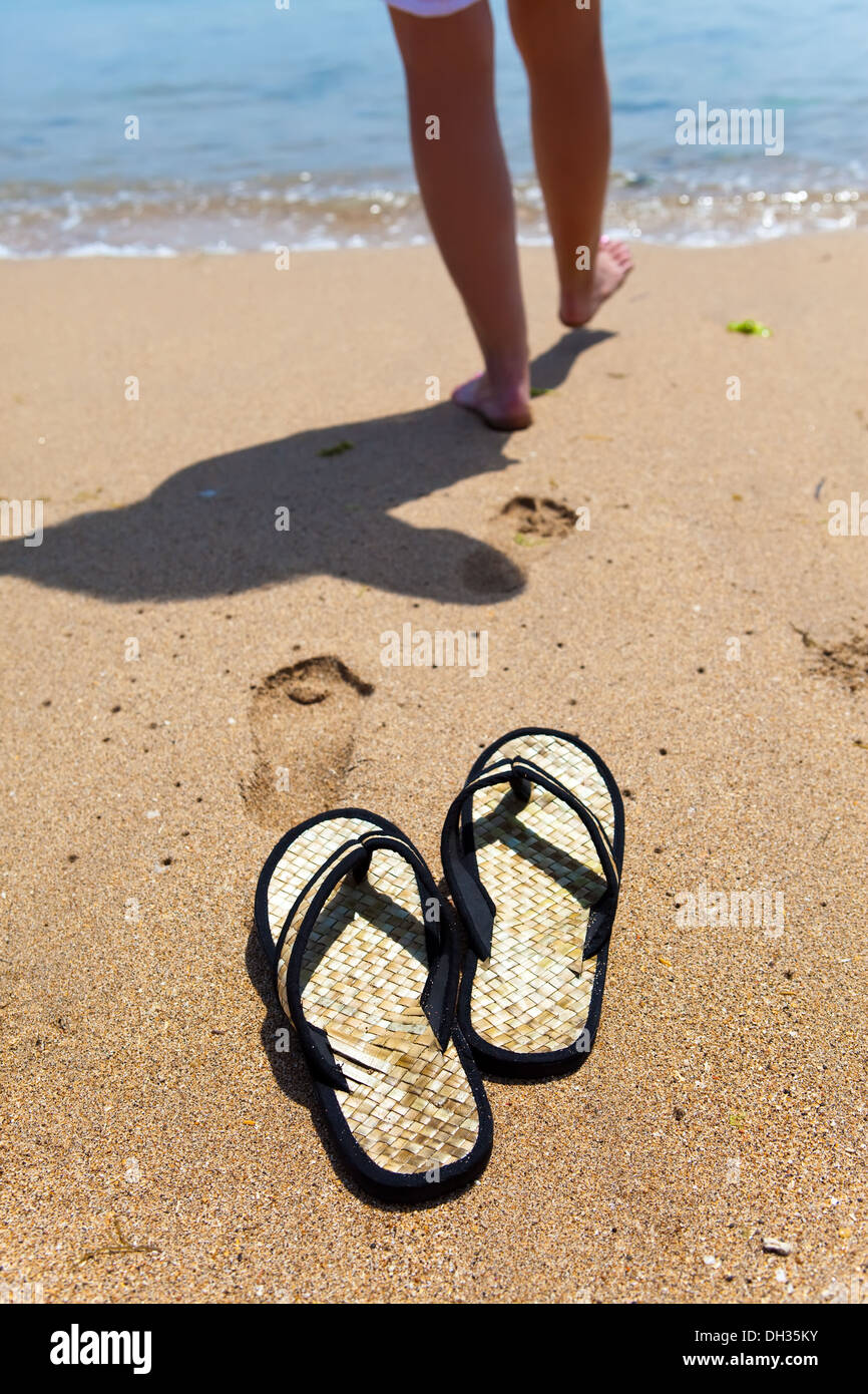 Beach slippers on sand, and female feet Stock Photo - Alamy