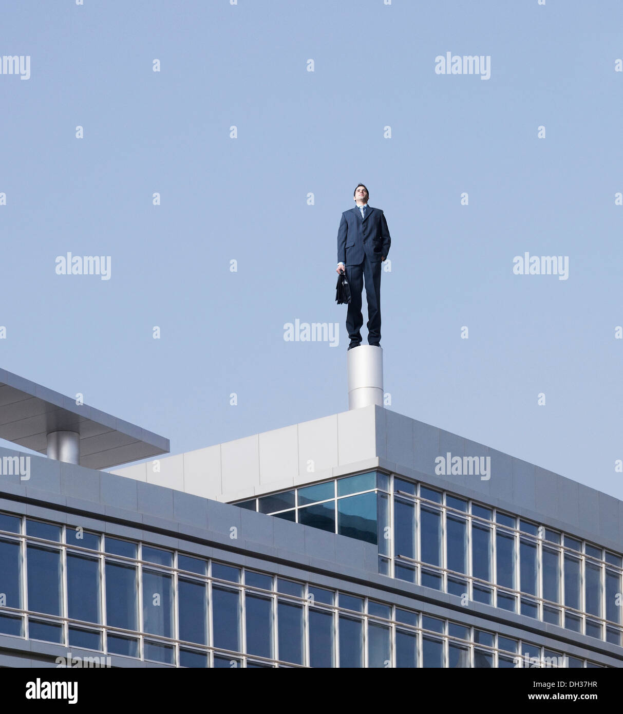 Low angle view of a businessman standing on a column Stock Photo - Alamy