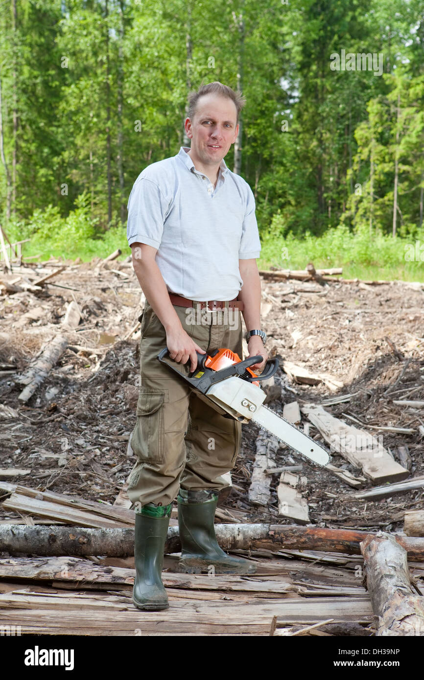 The man in wood saws a tree a chain saw Stock Photo - Alamy