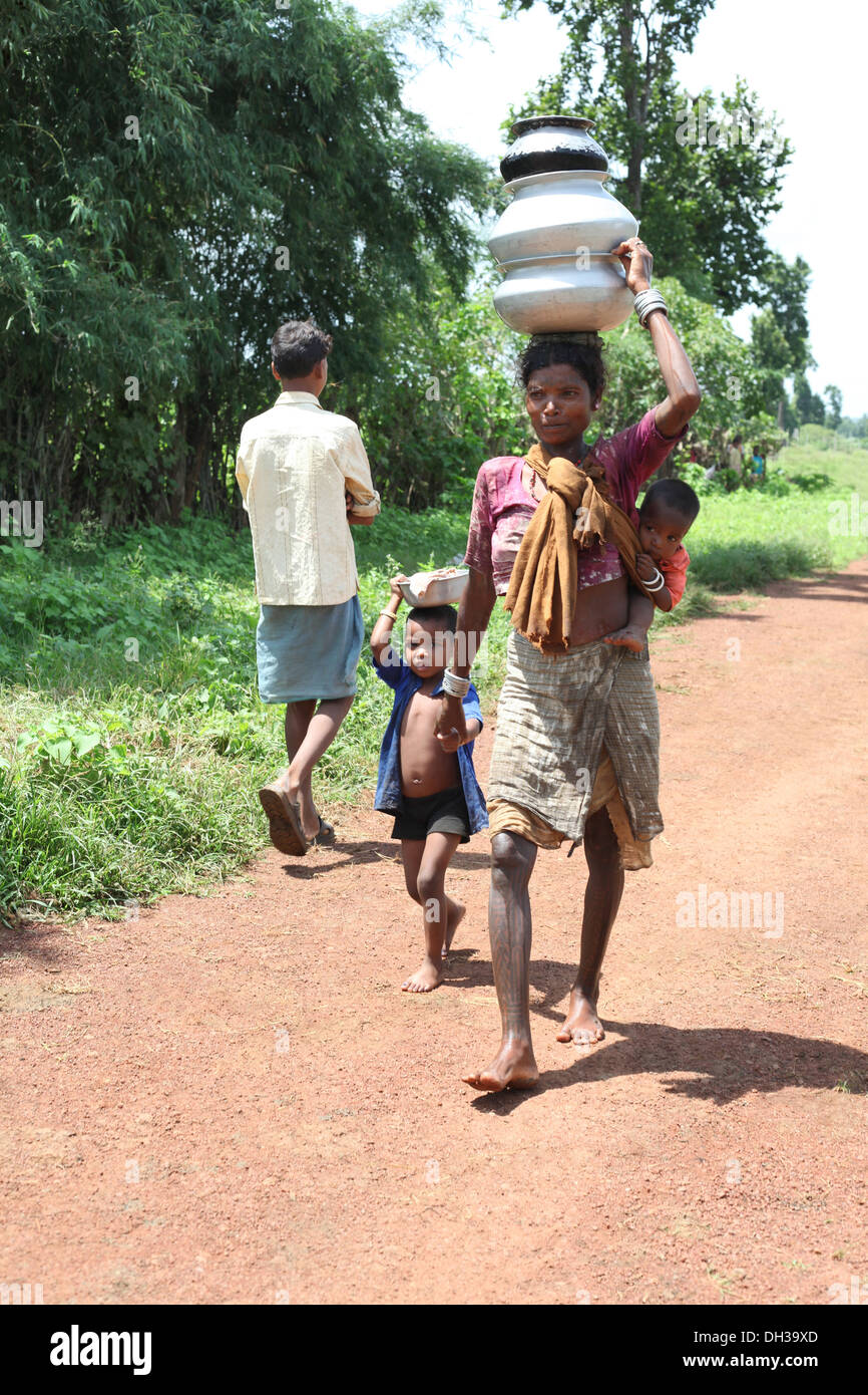 Tribal woman and children carrying water. Baiga Tribe, Chada village ...