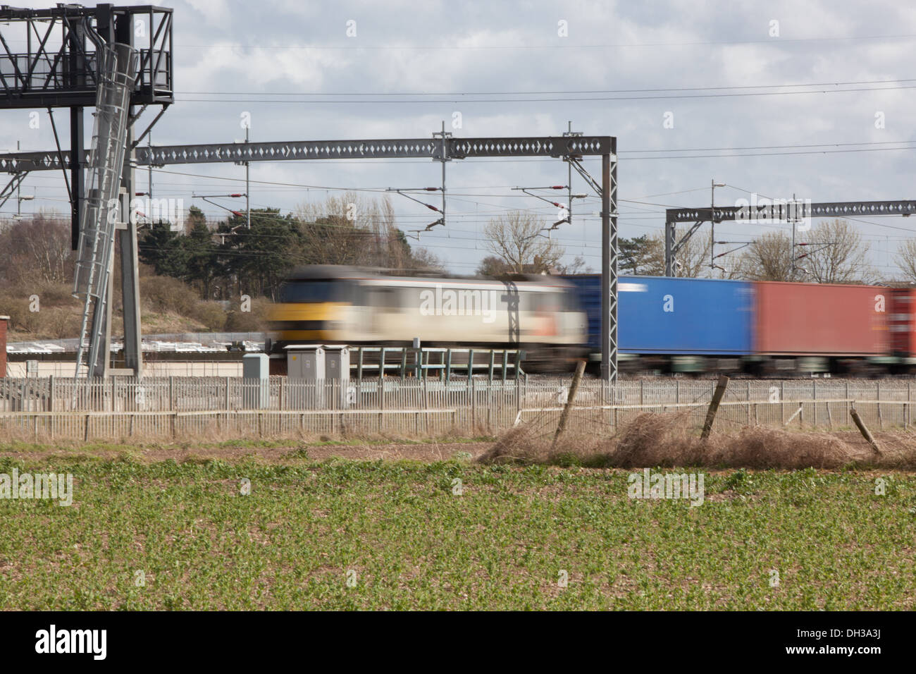 A freight train speeds along the West Coast Main Line in the Midlands ...