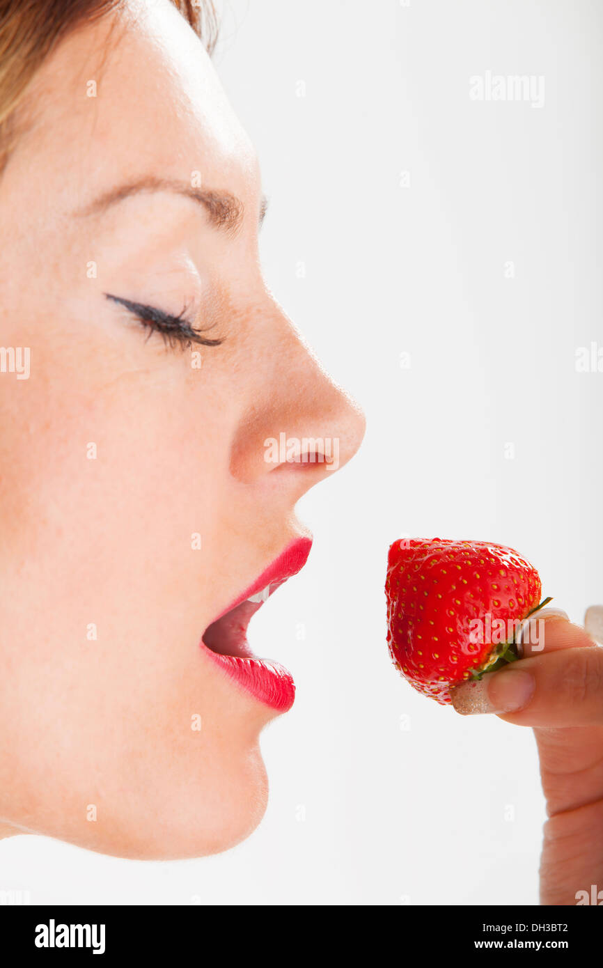 woman eating a strawberry Stock Photo - Alamy