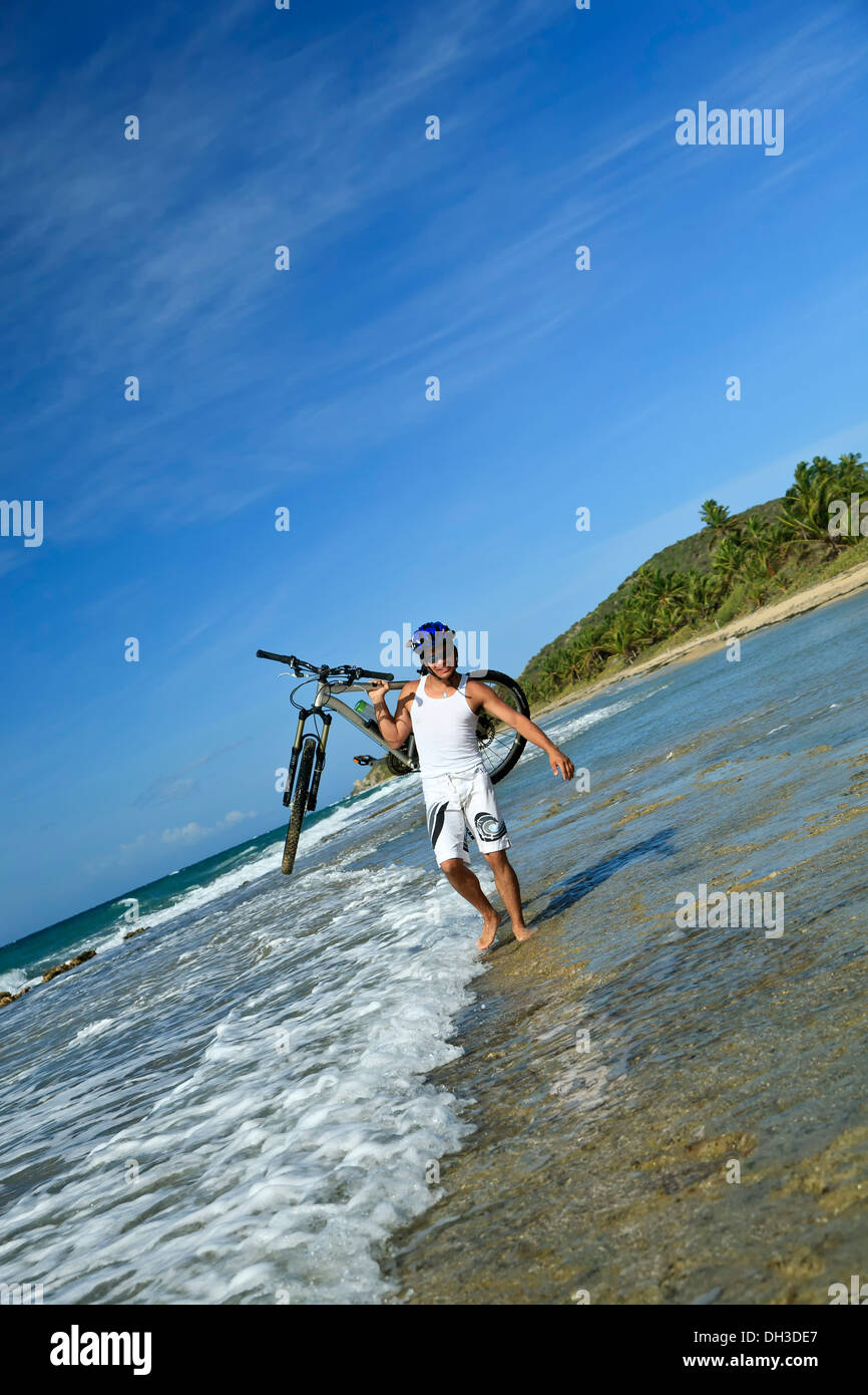 Mountain biker carrying bike on beach, Vieques, Puerto Rico Stock Photo ...