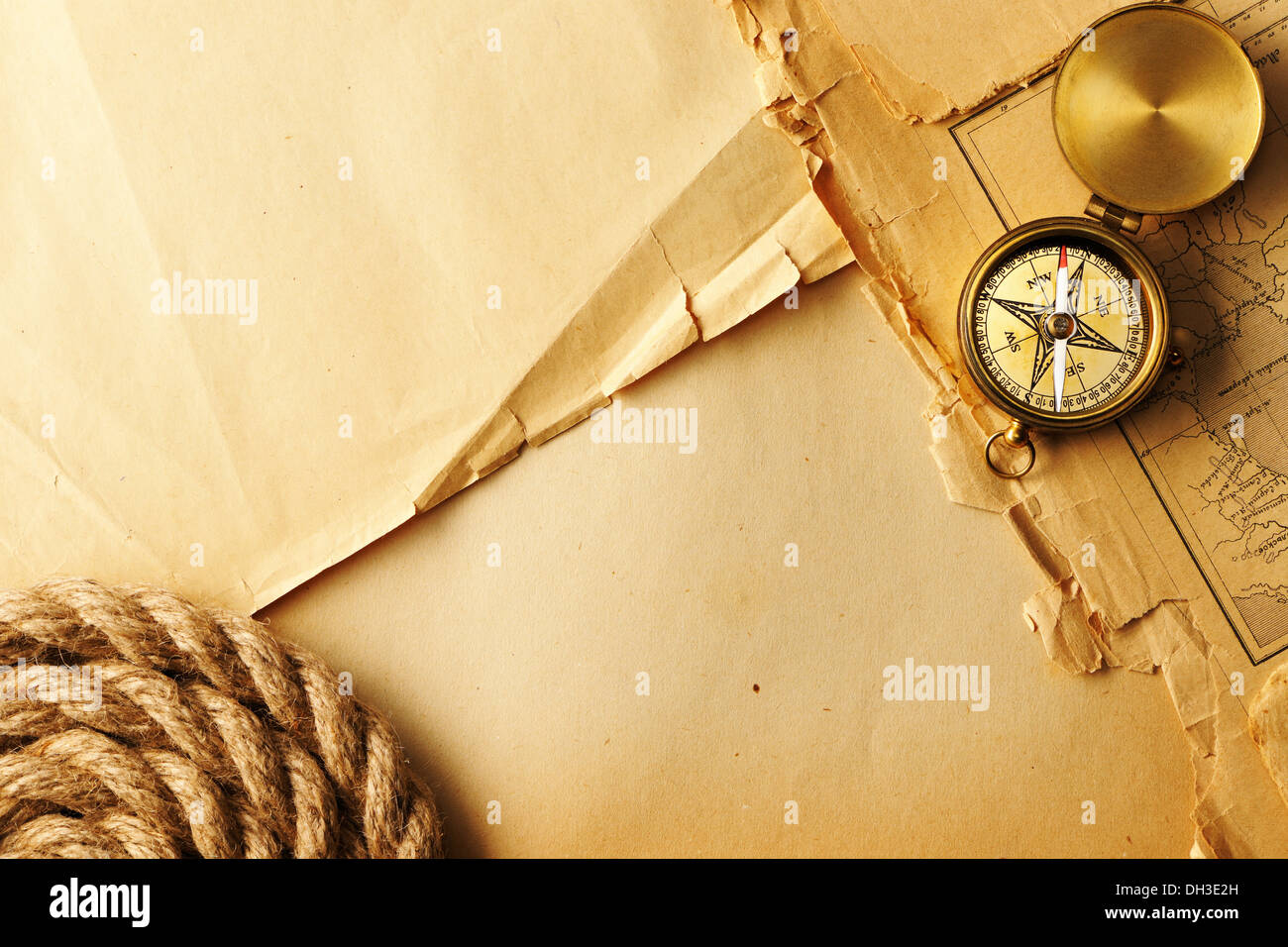 Antique compass and rope over old map Stock Photo - Alamy