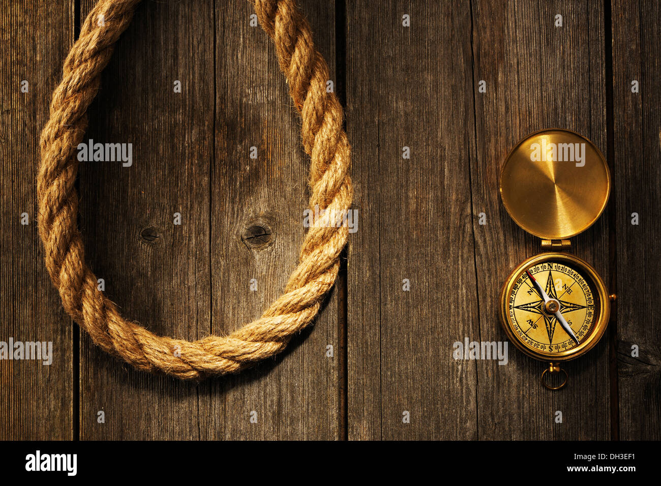 Antique compass and rope over wooden background Stock Photo - Alamy
