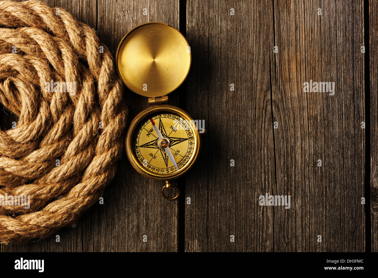 Antique compass and rope over wooden background Stock Photo - Alamy