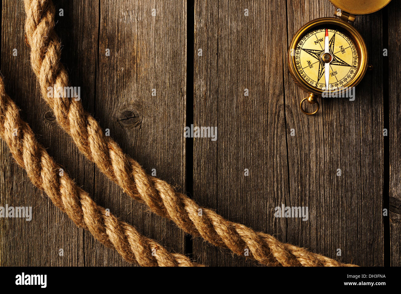 Antique compass and rope over wooden background Stock Photo - Alamy