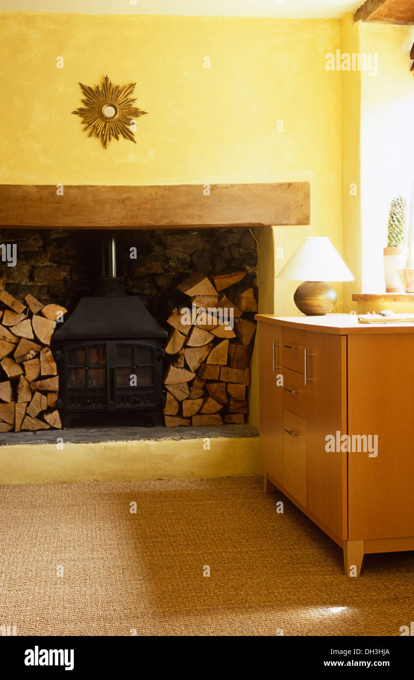 Logs stored either side of wood burning stove set in inglenook ...