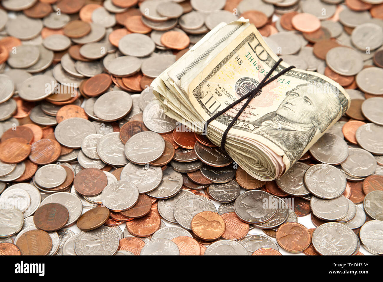 Folded and rubber banded stack of money laying on top of a pile of ...