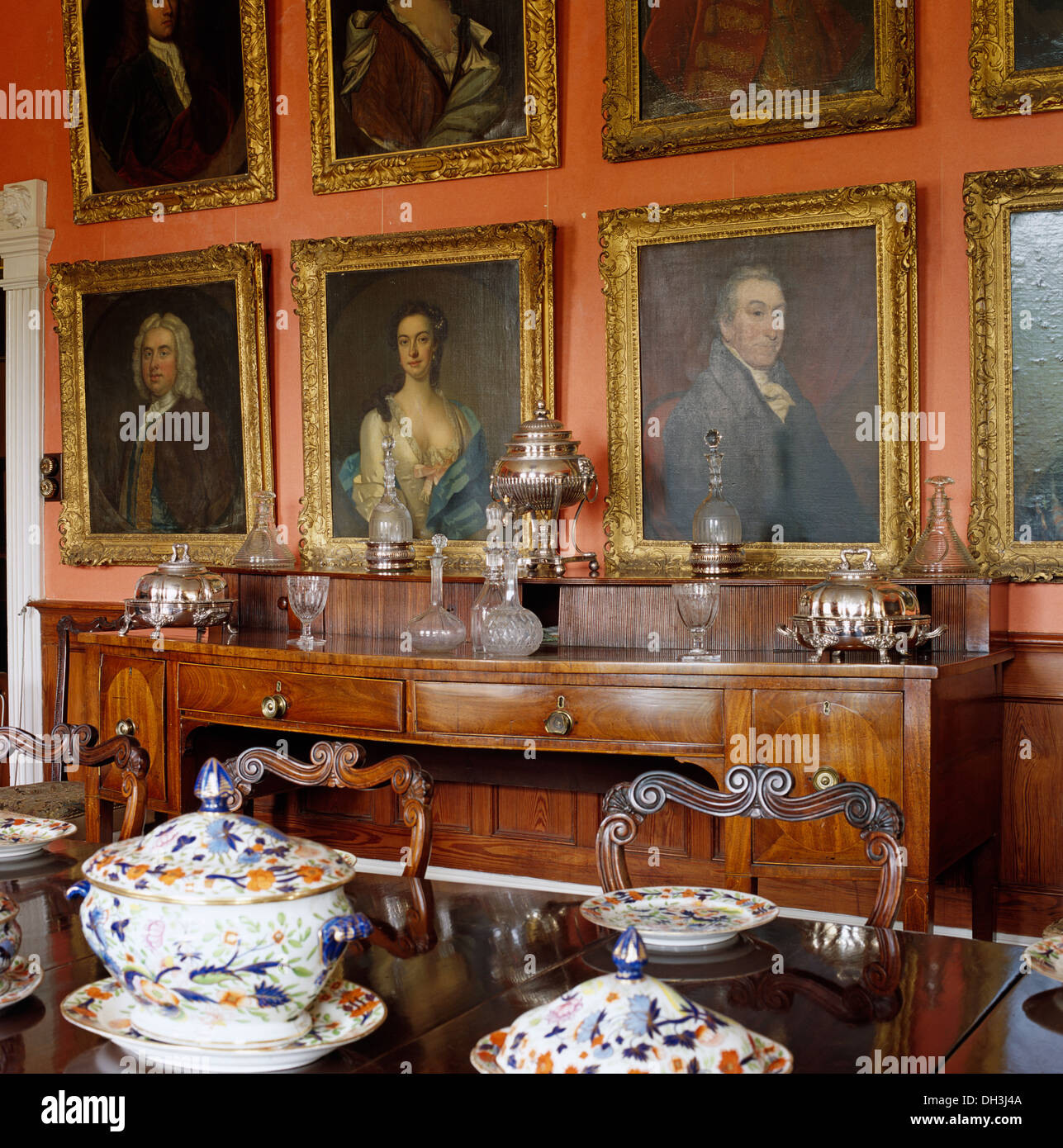 Group of ancestor portraits on wall above antique sideboard in grand ...